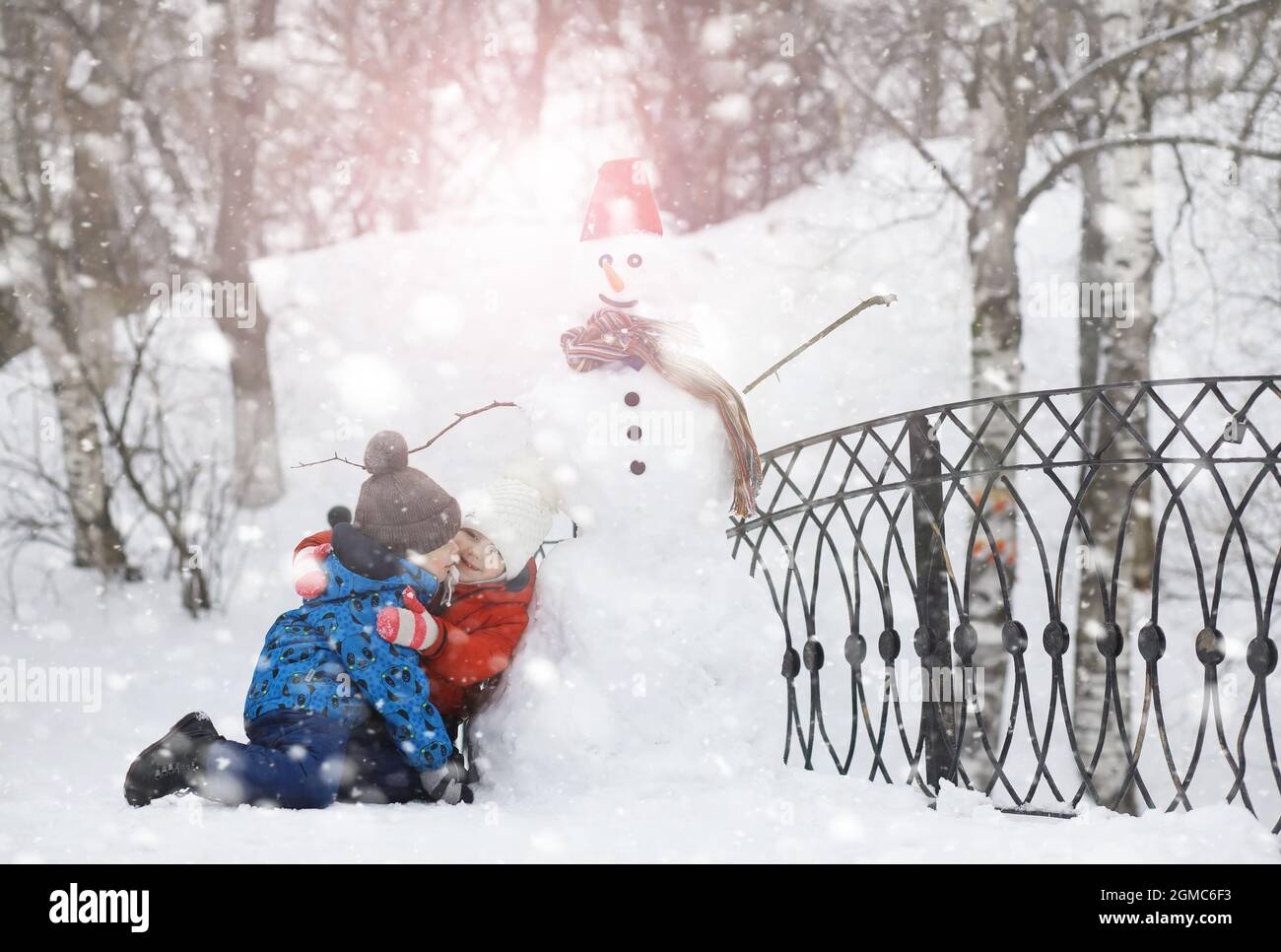 Children in the park in winter. Kids play with snow on the playground ...
