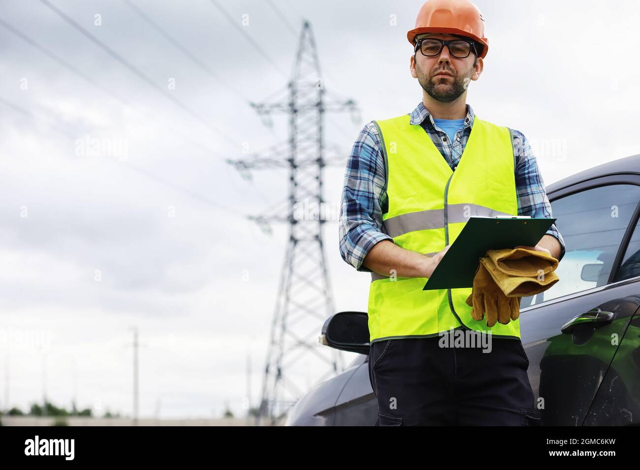 A man in a helmet and uniform, an electrician in the field ...