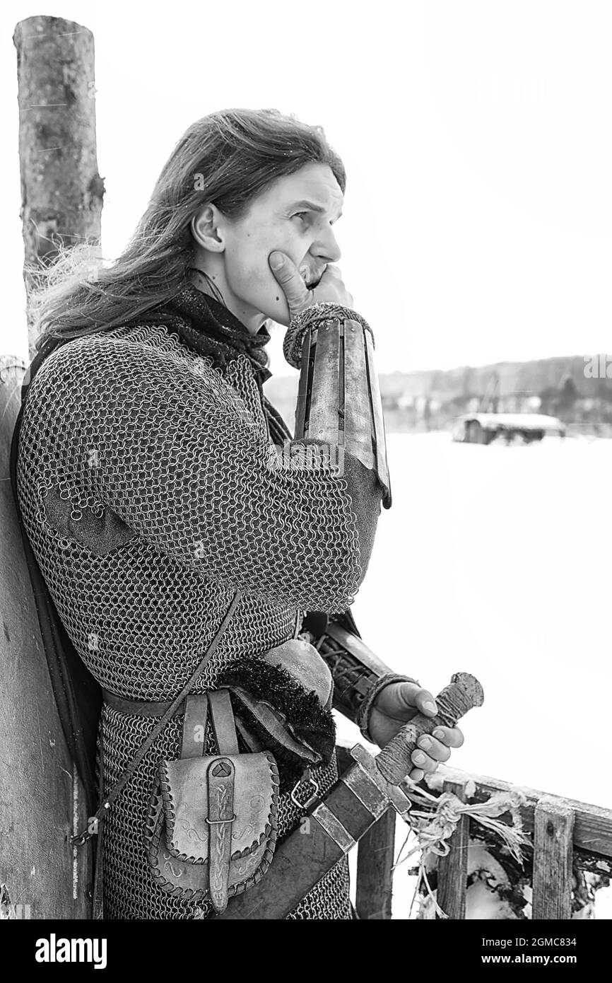 Defender the young warrior in mail armor armed with a sword and an ax ...