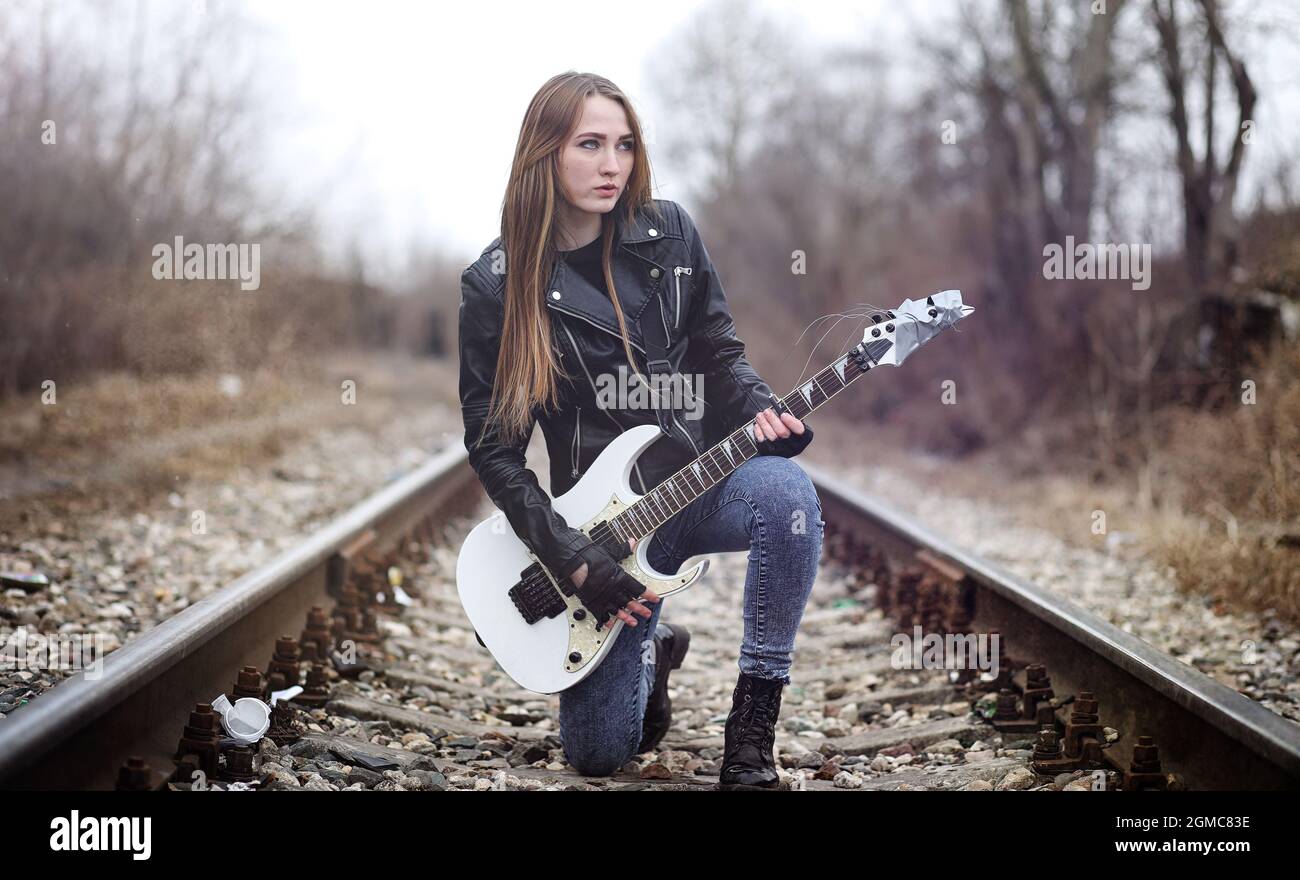 Beautiful young girl rocker with electric guitar. A rock musician girl ...