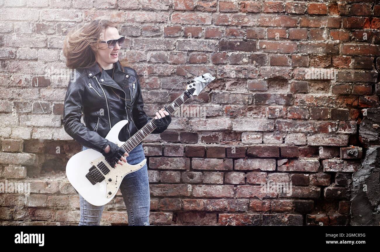 Beautiful young girl rocker with electric guitar. A rock musician girl ...