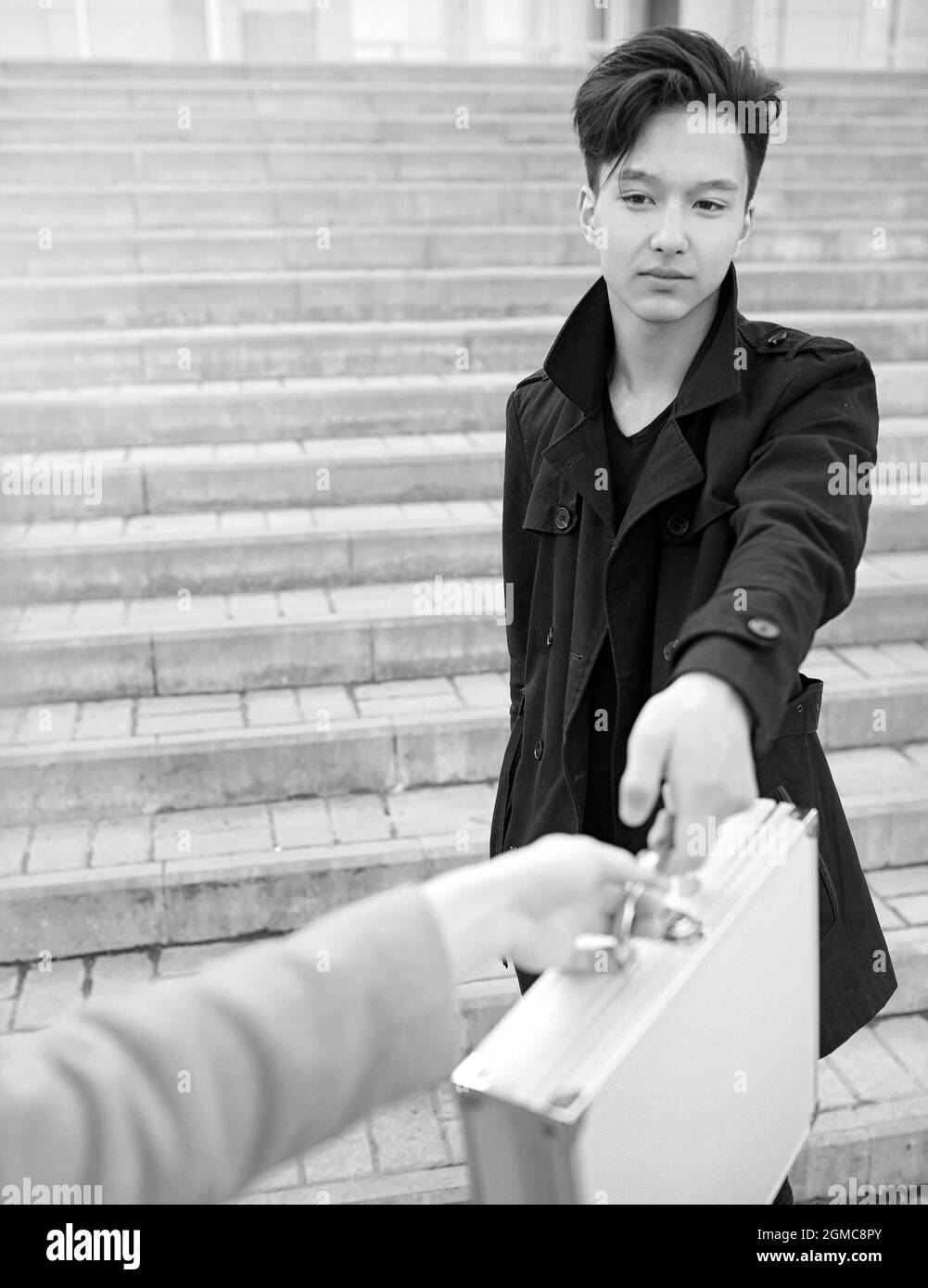 Asian man with a metal suitcase in the city. Asian and silver case ...