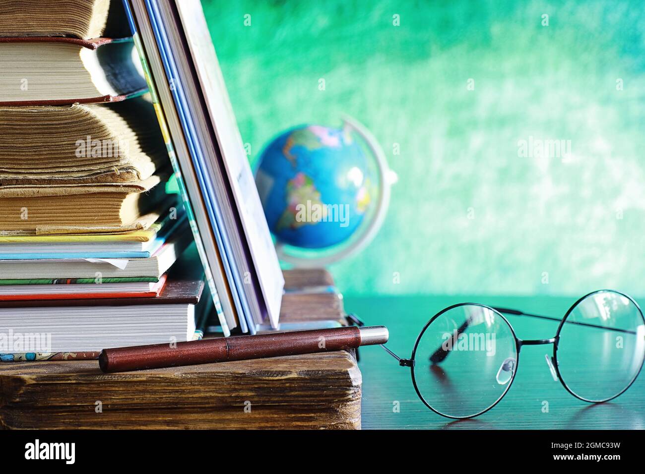 Education concept. A stack of textbooks and a book on the desk with ...