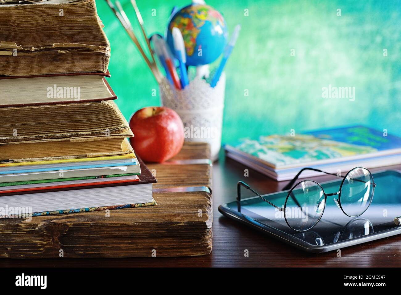 Education concept. A stack of textbooks and a book on the desk with ...