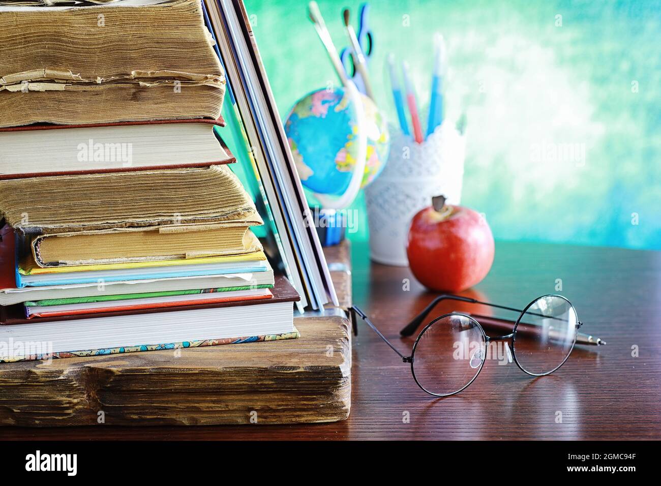 Education concept. A stack of textbooks and a book on the desk with ...