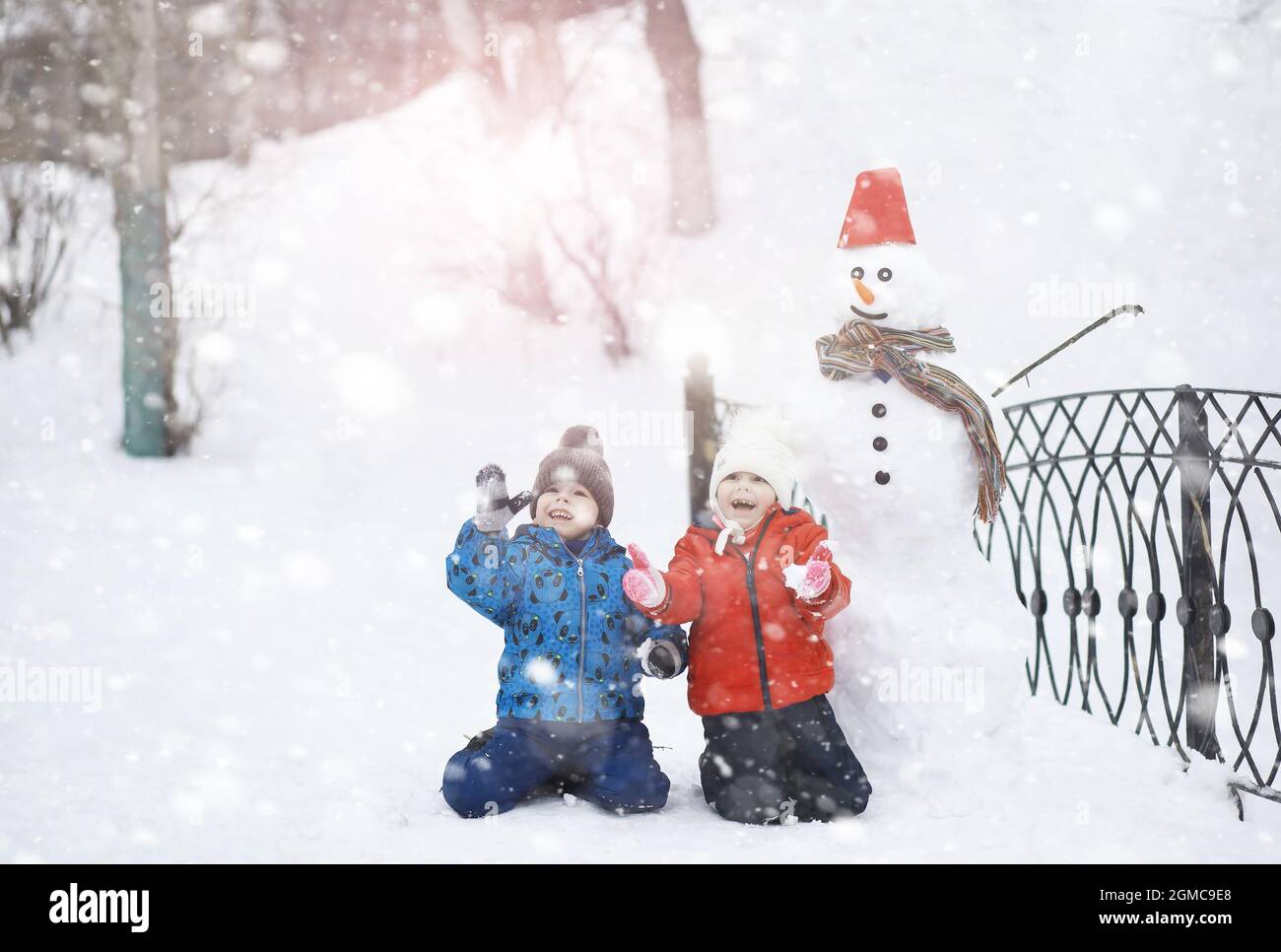 Children in the park in winter. Kids play with snow on the playground ...