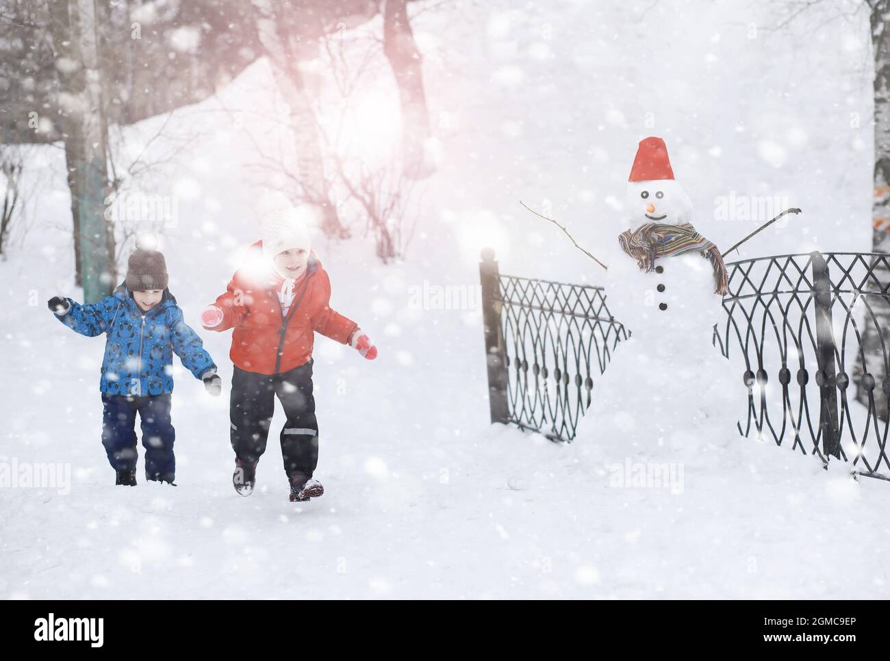 Children in the park in winter. Kids play with snow on the playground ...