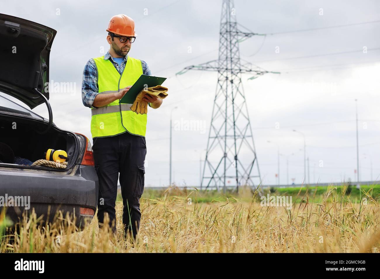 A man in a helmet and uniform, an electrician in the field ...