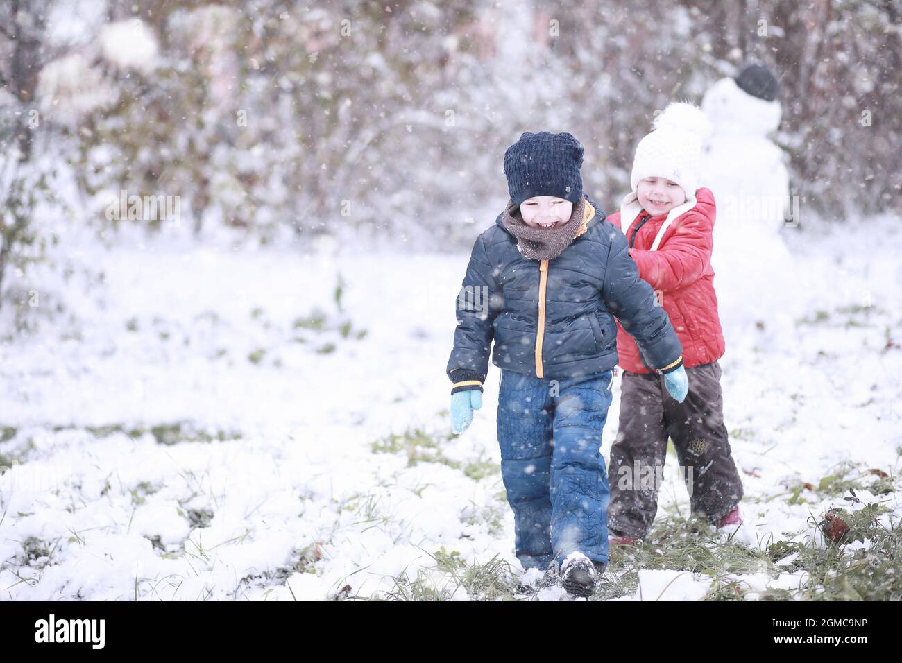 Kids walk in the park with first snow Stock Photo - Alamy