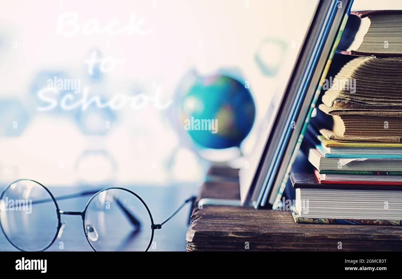 Education concept. A stack of textbooks and a book on the desk with ...