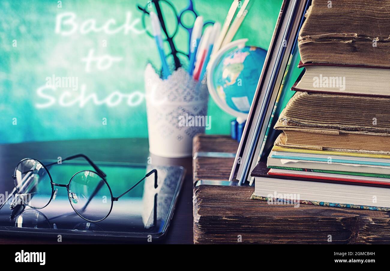 Education concept. A stack of textbooks and a book on the desk with ...