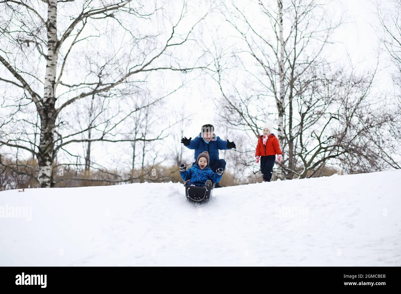 Children in the park in winter. Kids play with snow on the playground ...