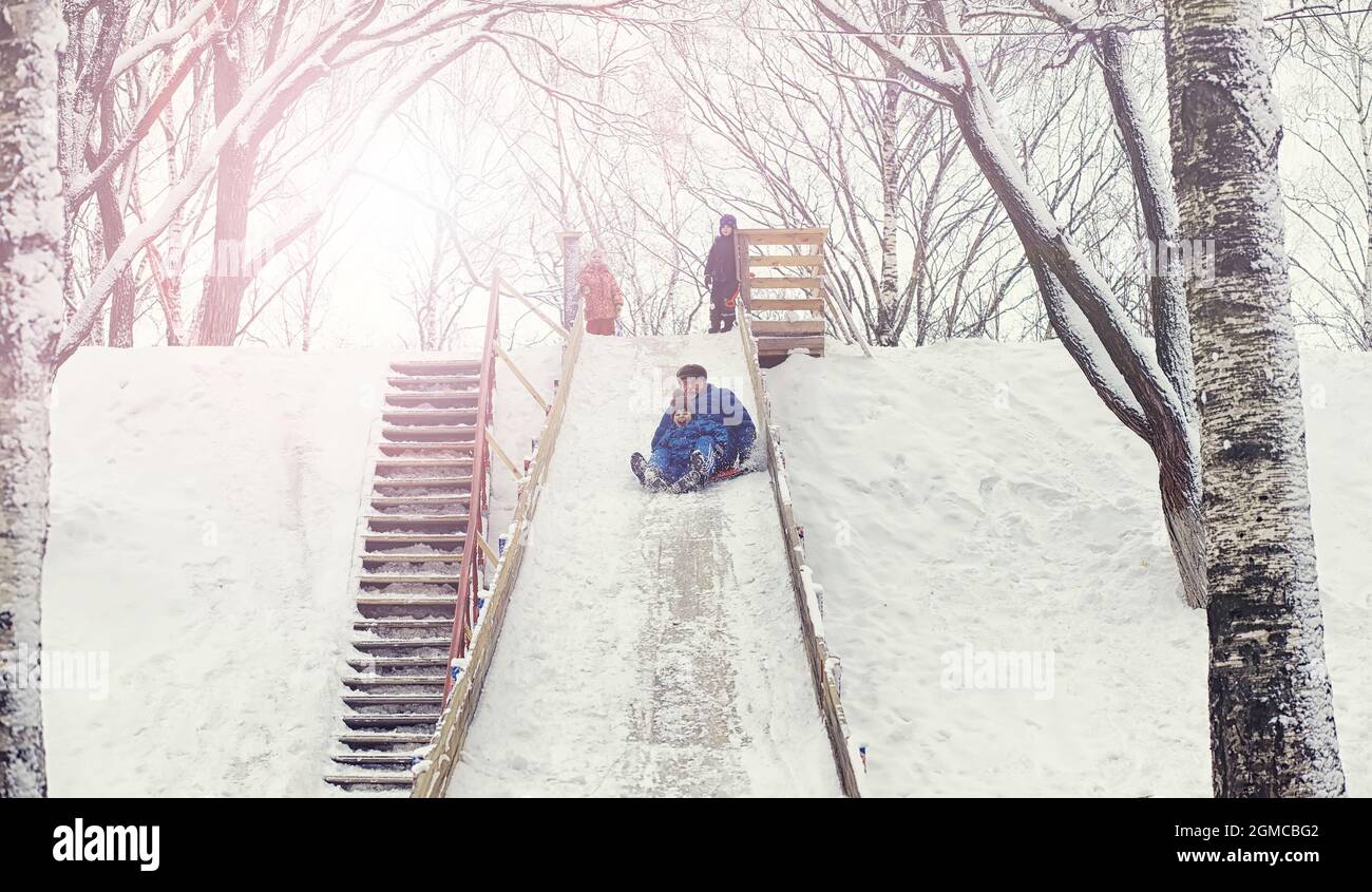 Children in the park in winter. Kids play with snow on playground. They ...