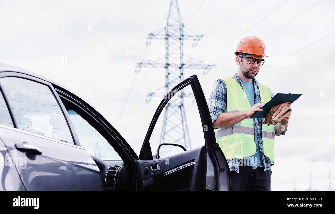 A man in a helmet and uniform, an electrician in the field ...
