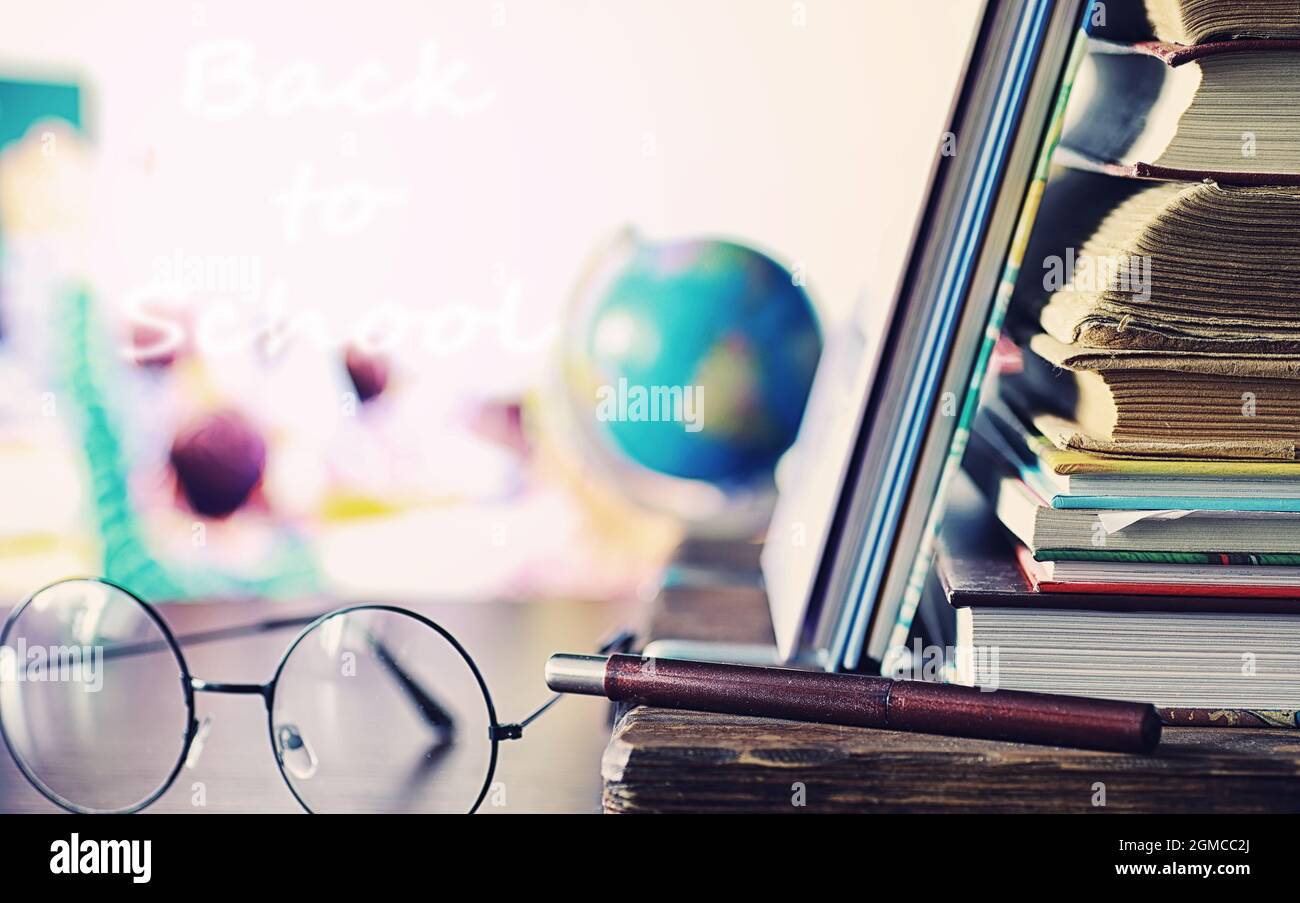 Education concept. A stack of textbooks and a book on the desk with ...