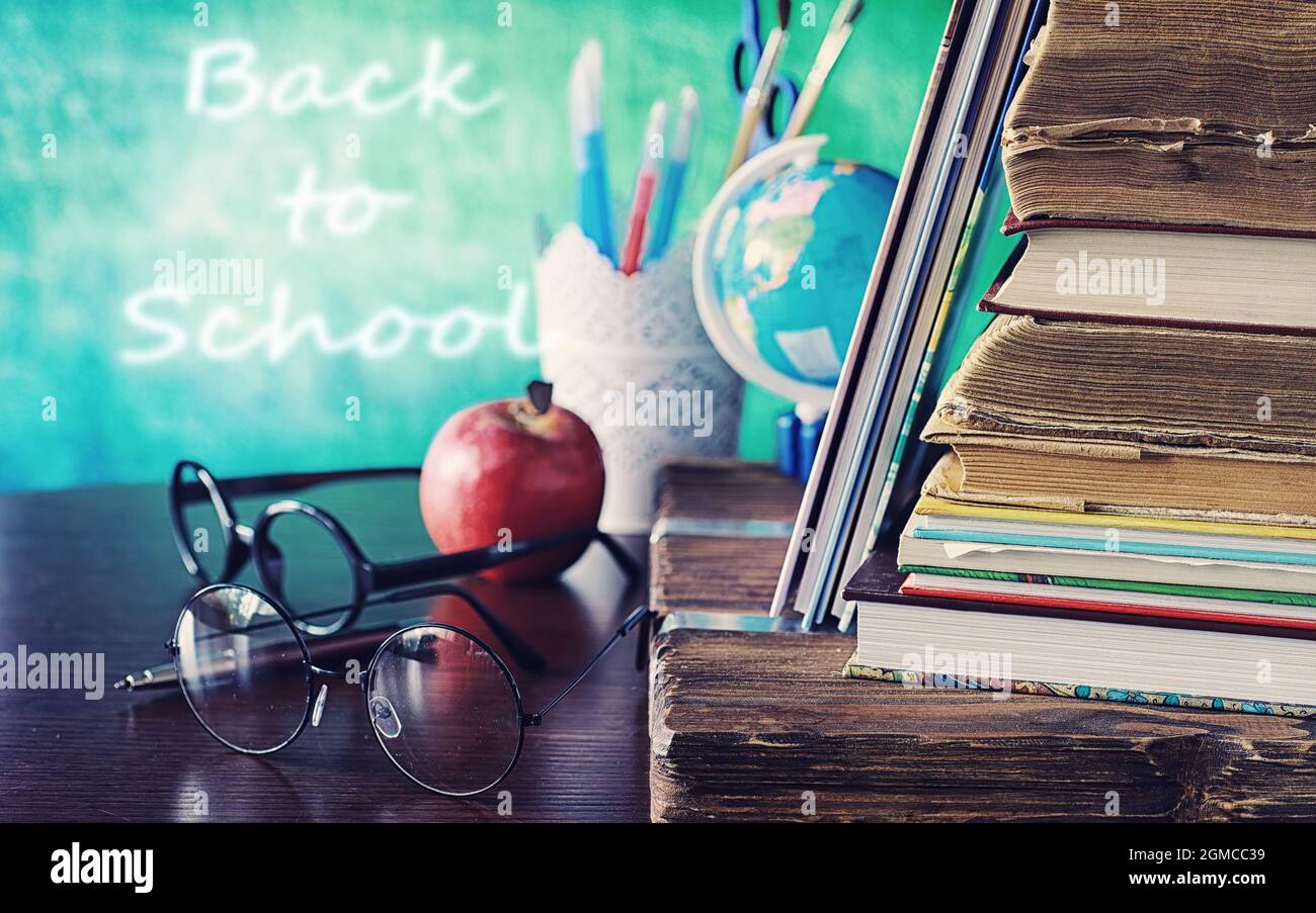 Education concept. A stack of textbooks and a book on the desk with ...