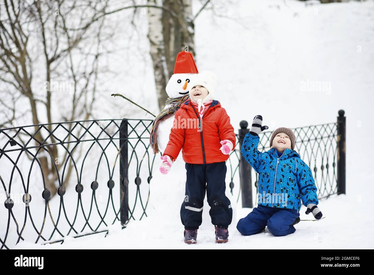 Children in the park in winter. Kids play with snow on the playground ...