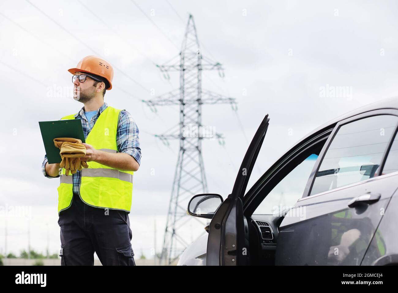 A man in a helmet and uniform, an electrician in the field ...