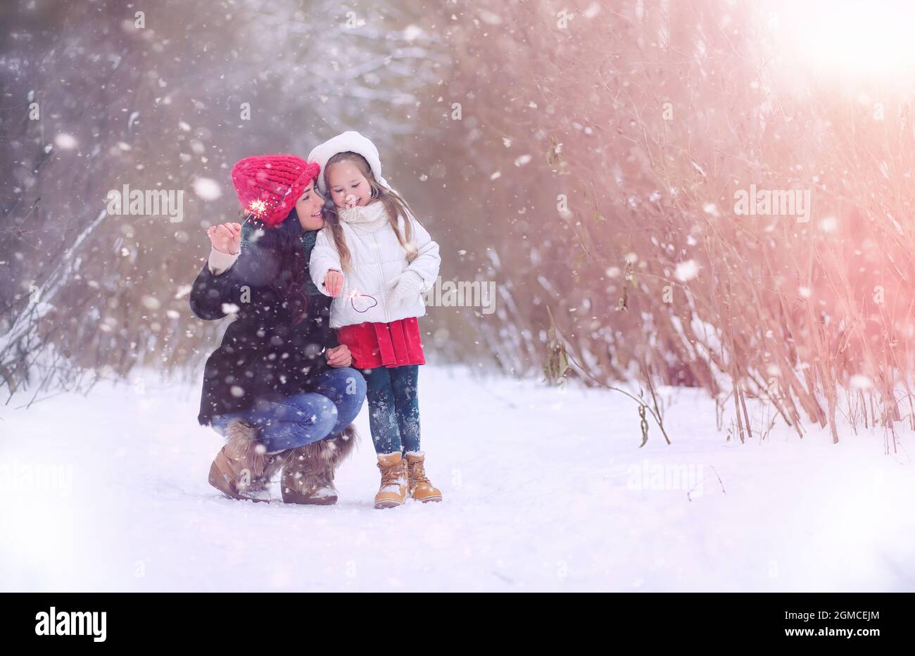 Winter fairy tale, a young mother and her daughter ride a sled in the ...