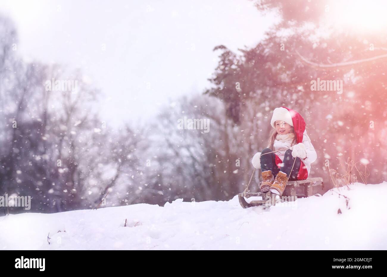 Winter fairy tale, a young mother and her daughter ride a sled in the ...