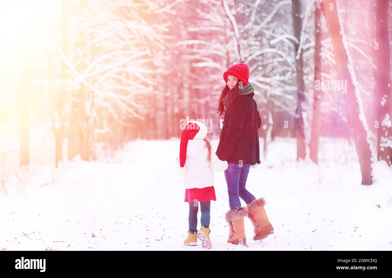 Winter fairy tale, a young mother and her daughter ride a sled in the ...
