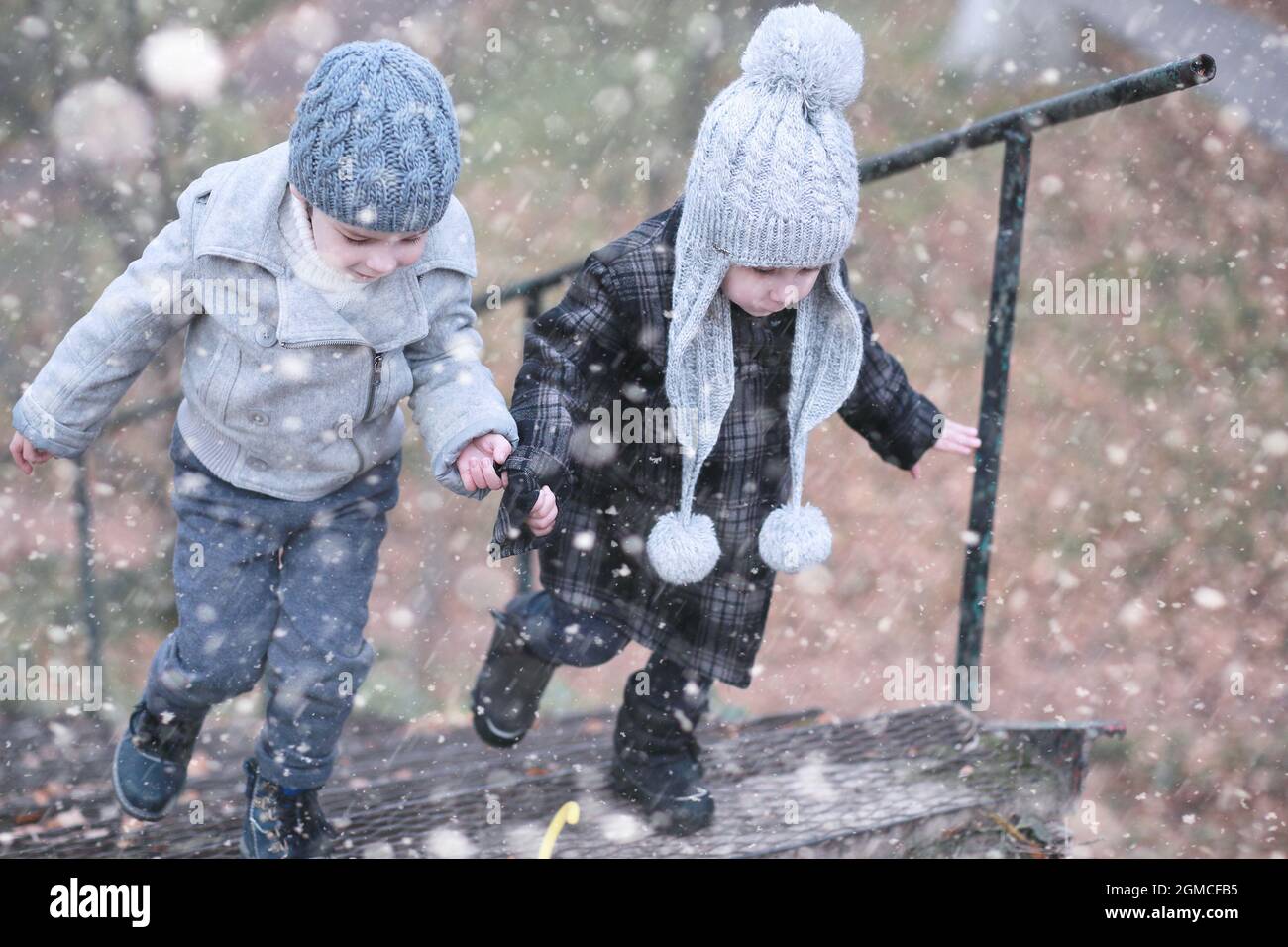 Kids walk in the park with first snow Stock Photo - Alamy