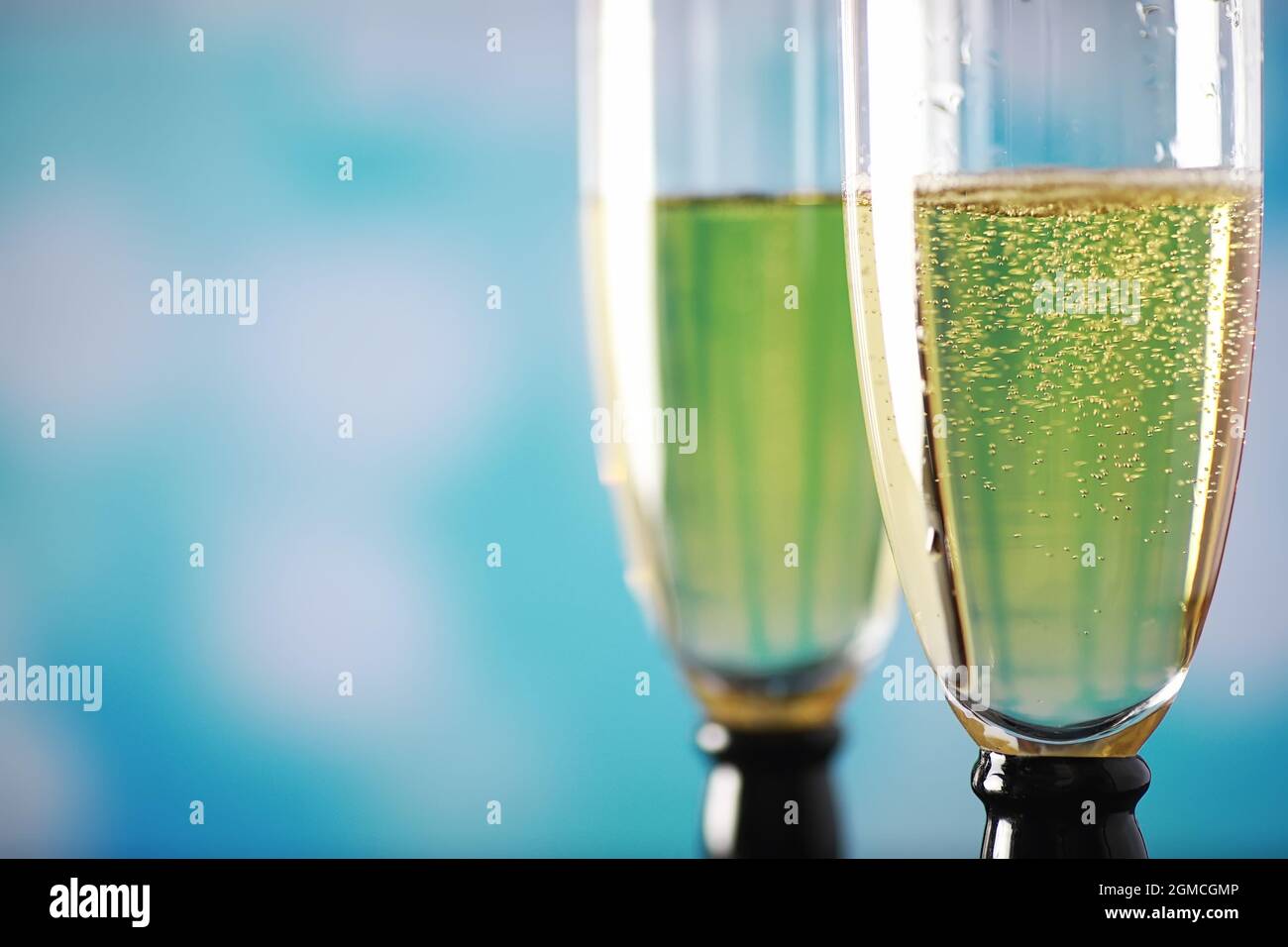 Background with tall glasses for sparkling wines. Champagne spray in ...