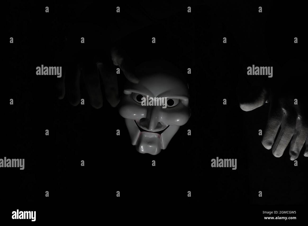 White scary mask on a black background with whites hands Stock Photo ...