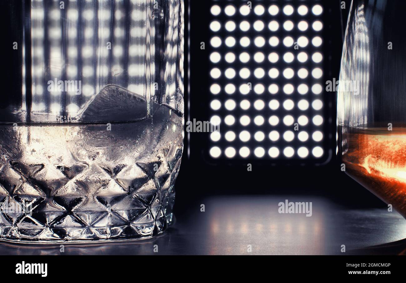 A glass of hard alcohol with ice on a bar counter. Whiskey with soda in ...
