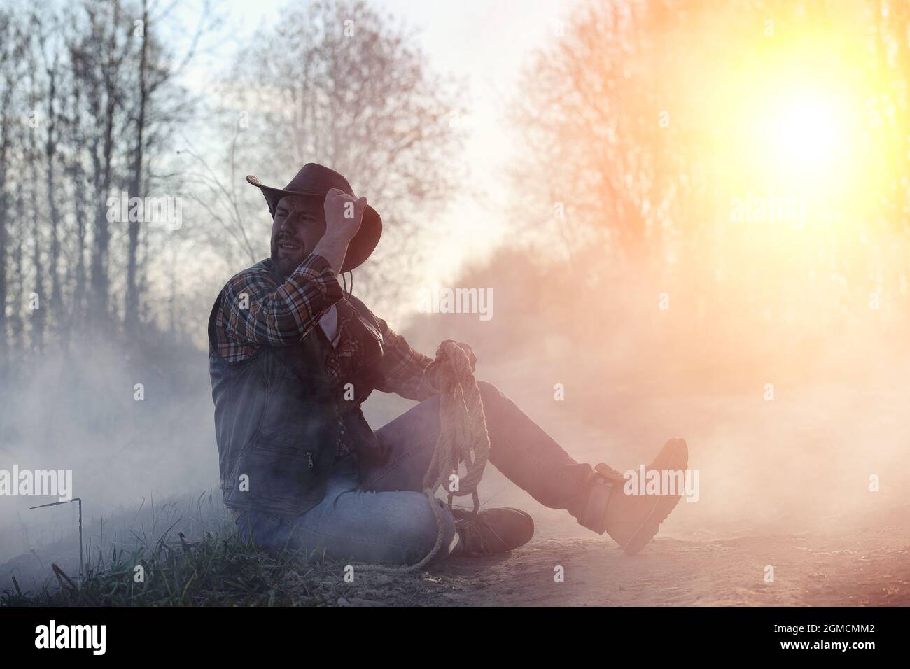 A man is wearing a cowboy hat and a loso in the field. American farmer ...