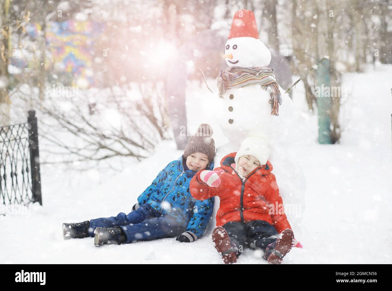 Children in the park in winter. Kids play with snow on the playground ...