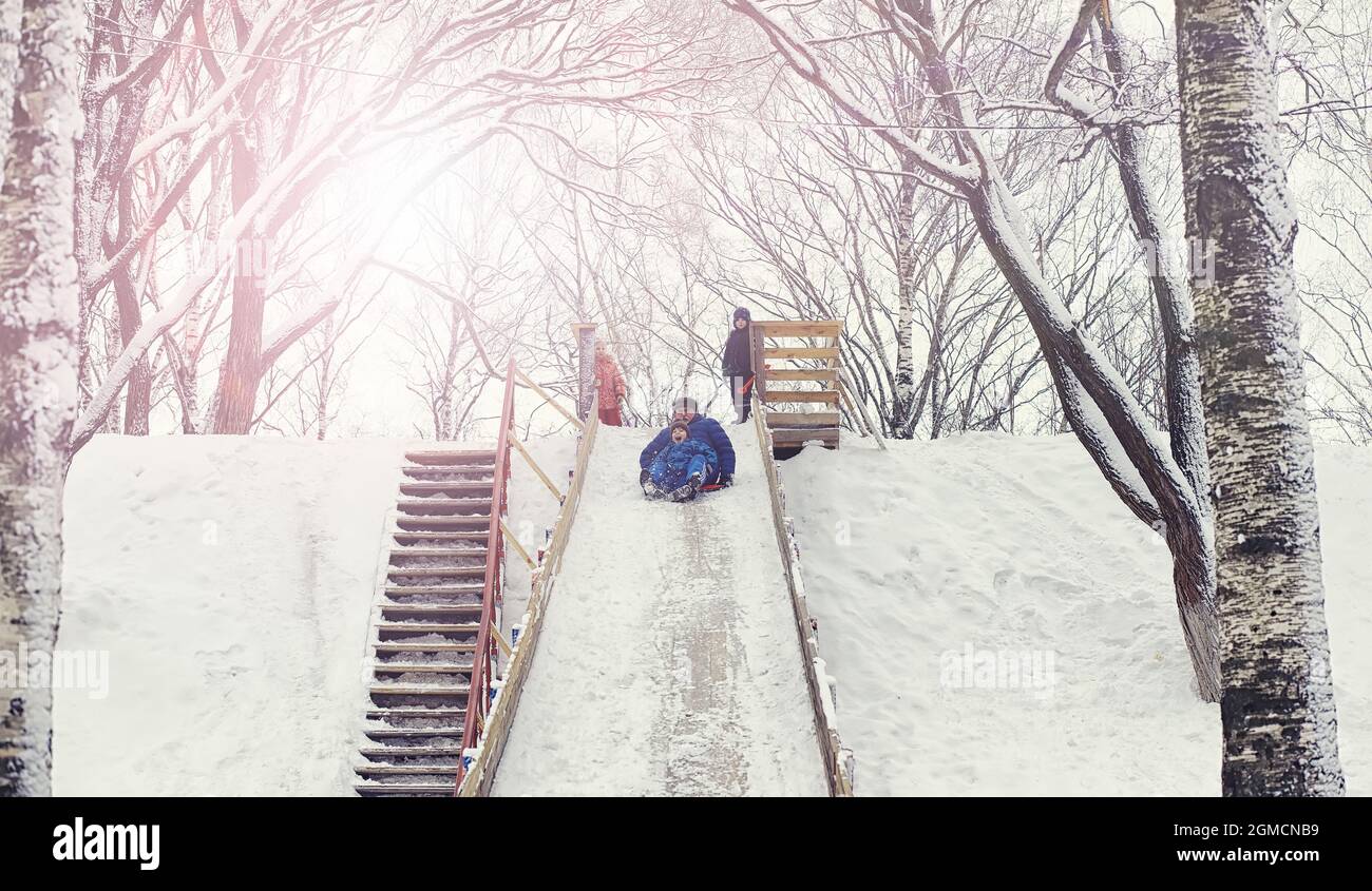 Children in the park in winter. Kids play with snow on playground. They ...