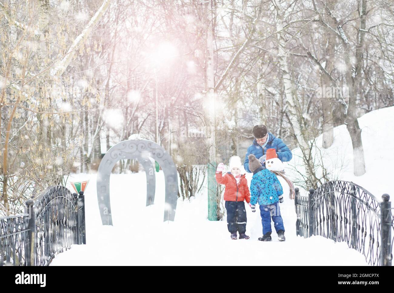 Children in the park in winter. Kids play with snow on the playground ...