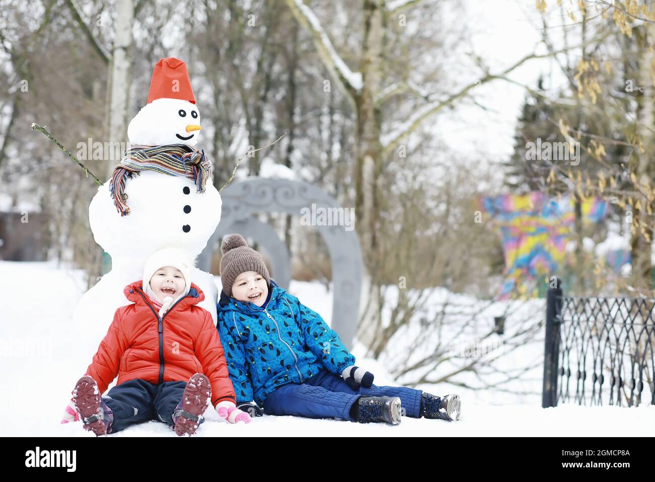 Children in the park in winter. Kids play with snow on the playground ...
