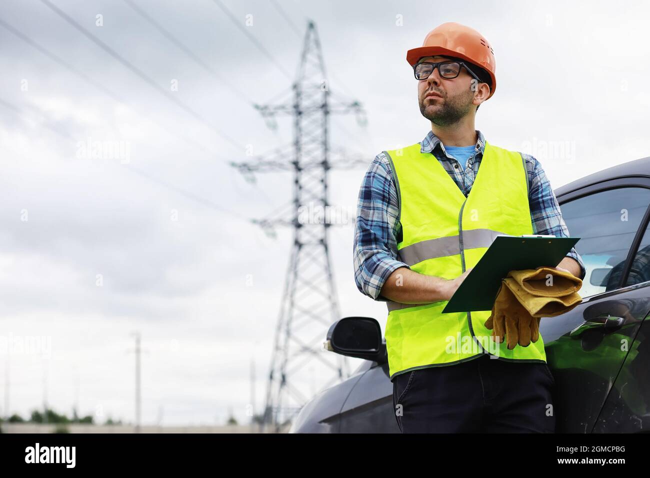 A man in a helmet and uniform, an electrician in the field ...