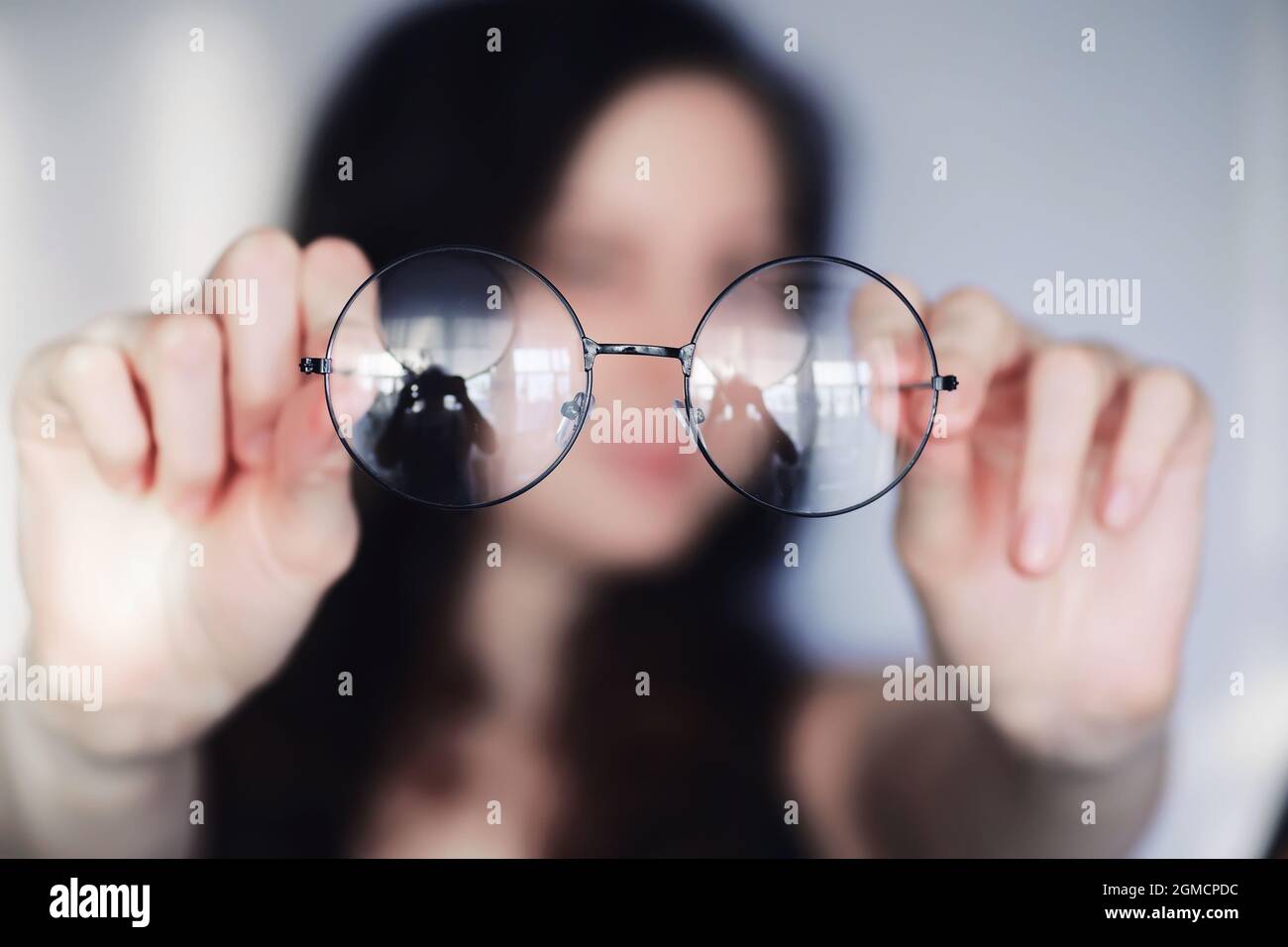 The concept of poor vision. Hold a contact lens and glasses in hand ...