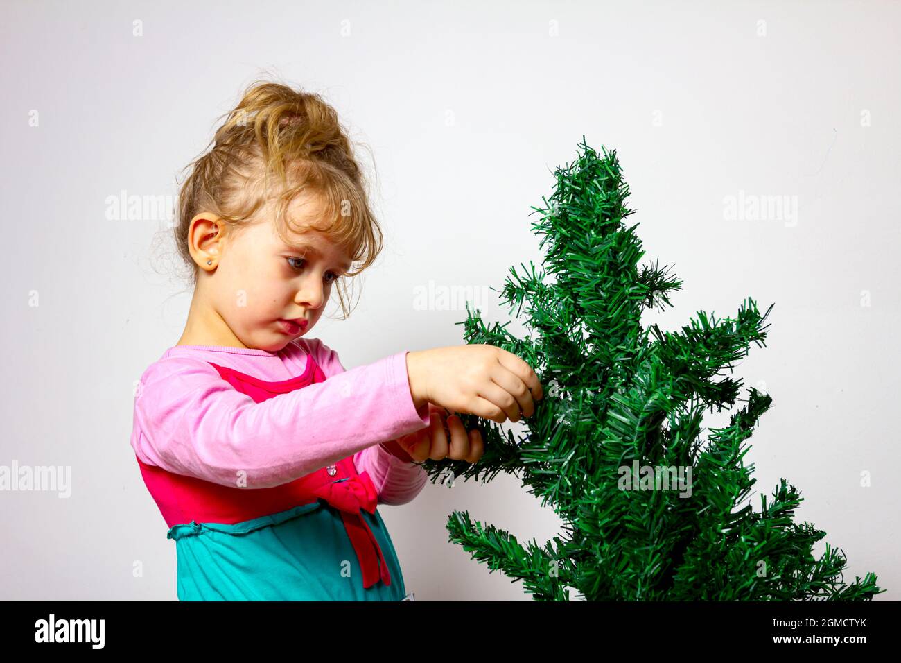 Preschooler female kid, child girl is assembly plastic evergreen, pine ...