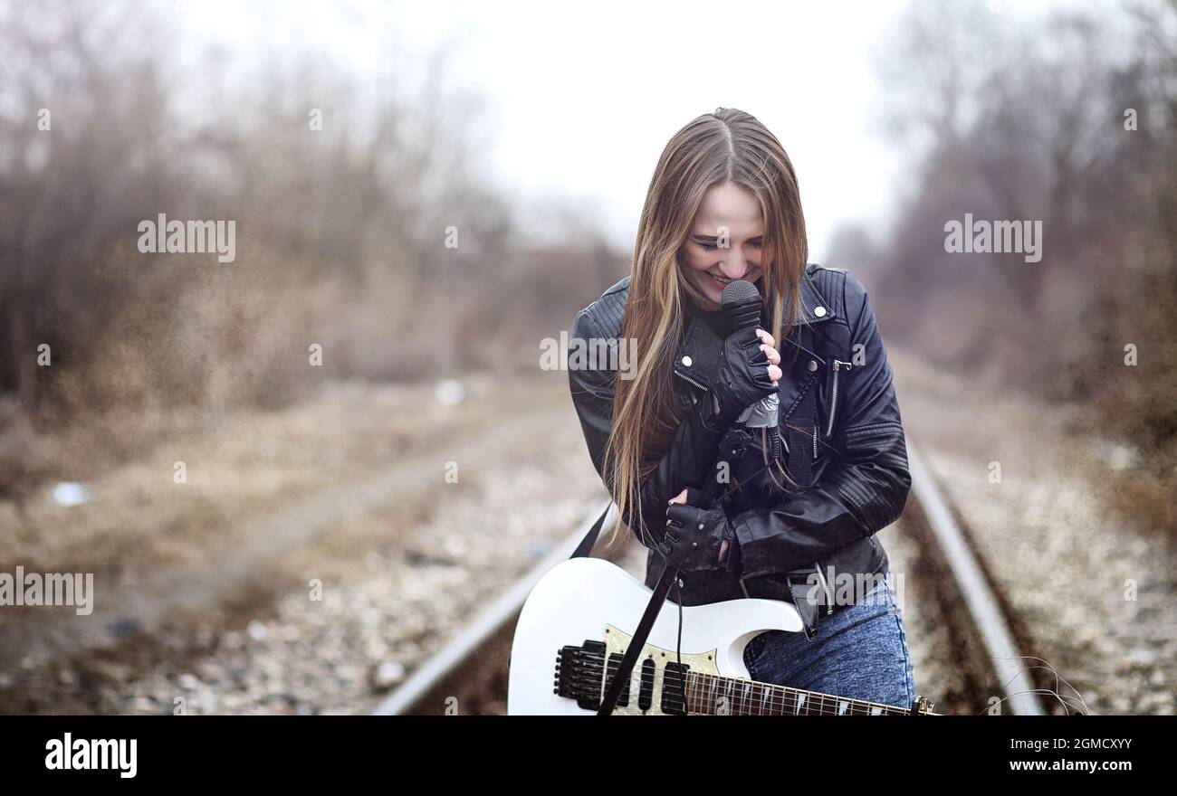 Beautiful young girl rocker with electric guitar. A rock musician girl ...