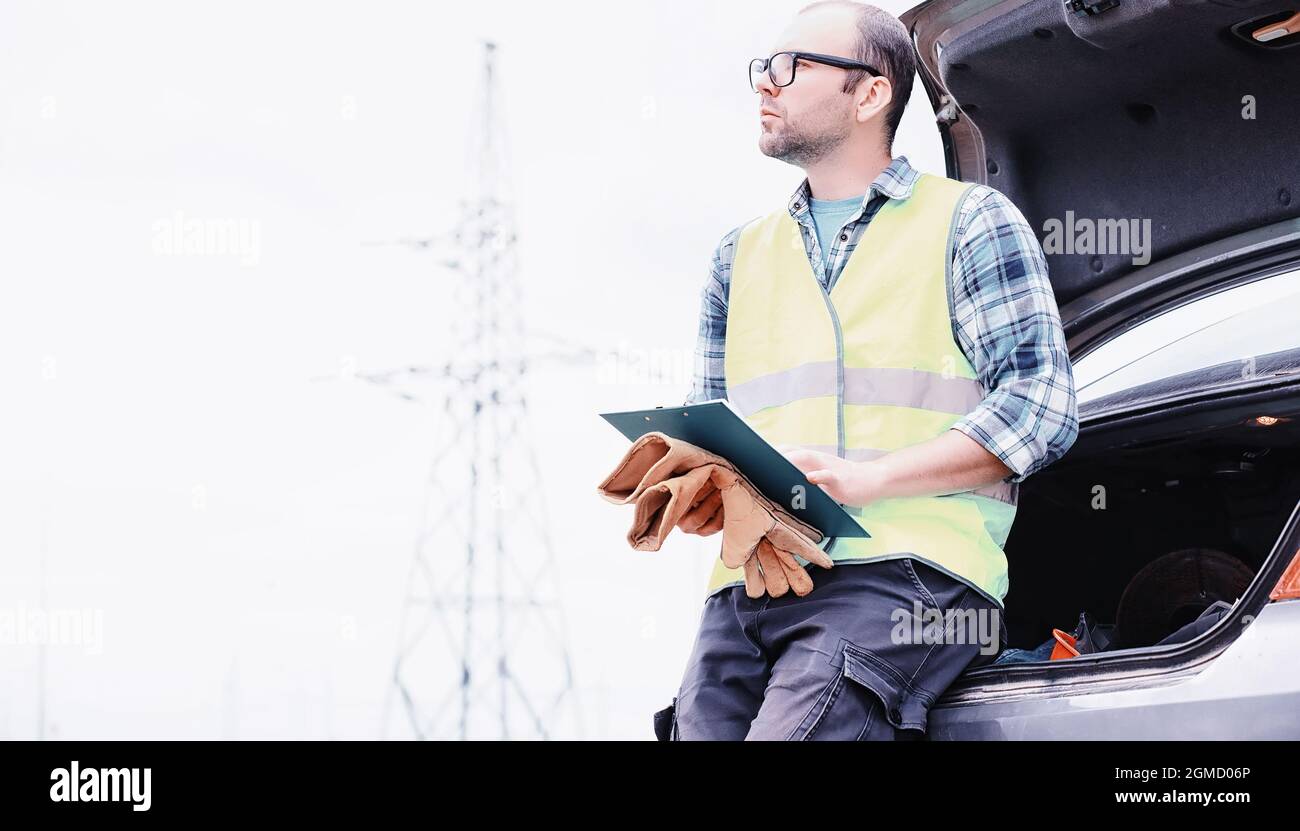 A man in a helmet and uniform, an electrician in the field ...