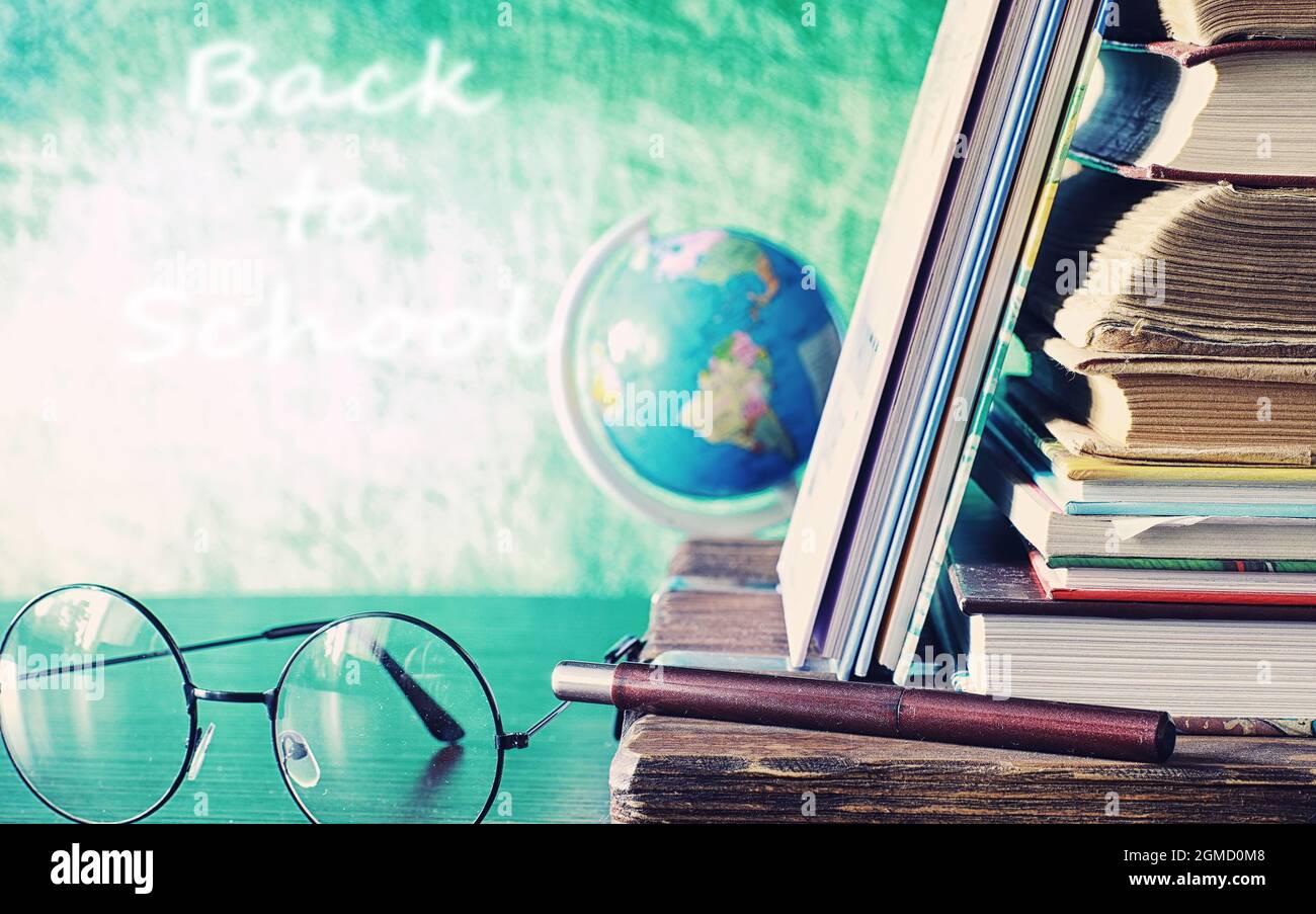 Education concept. A stack of textbooks and a book on the desk with ...