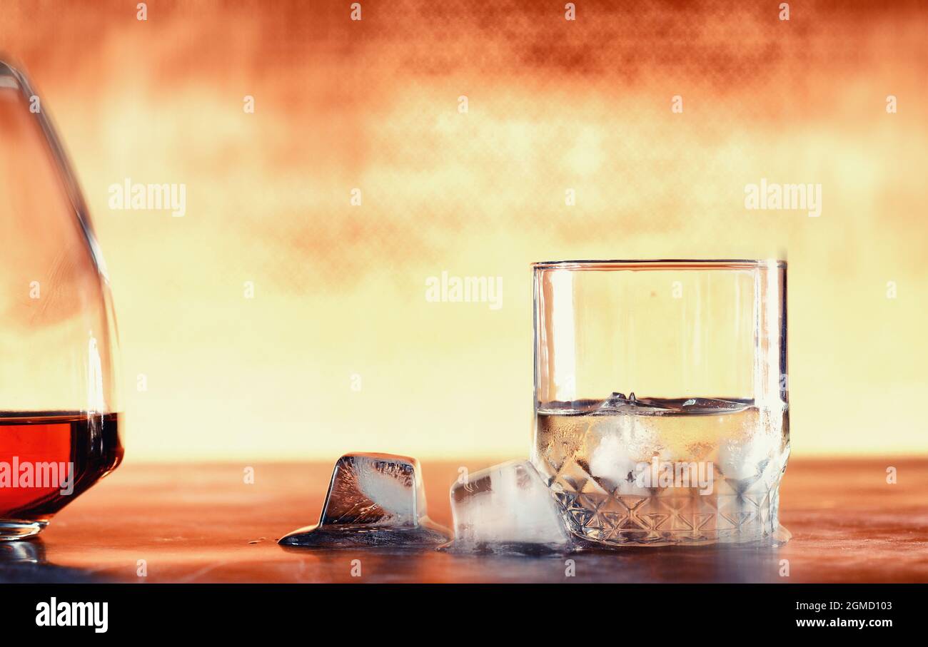 A glass of hard alcohol with ice on a bar counter. Whiskey with soda in ...