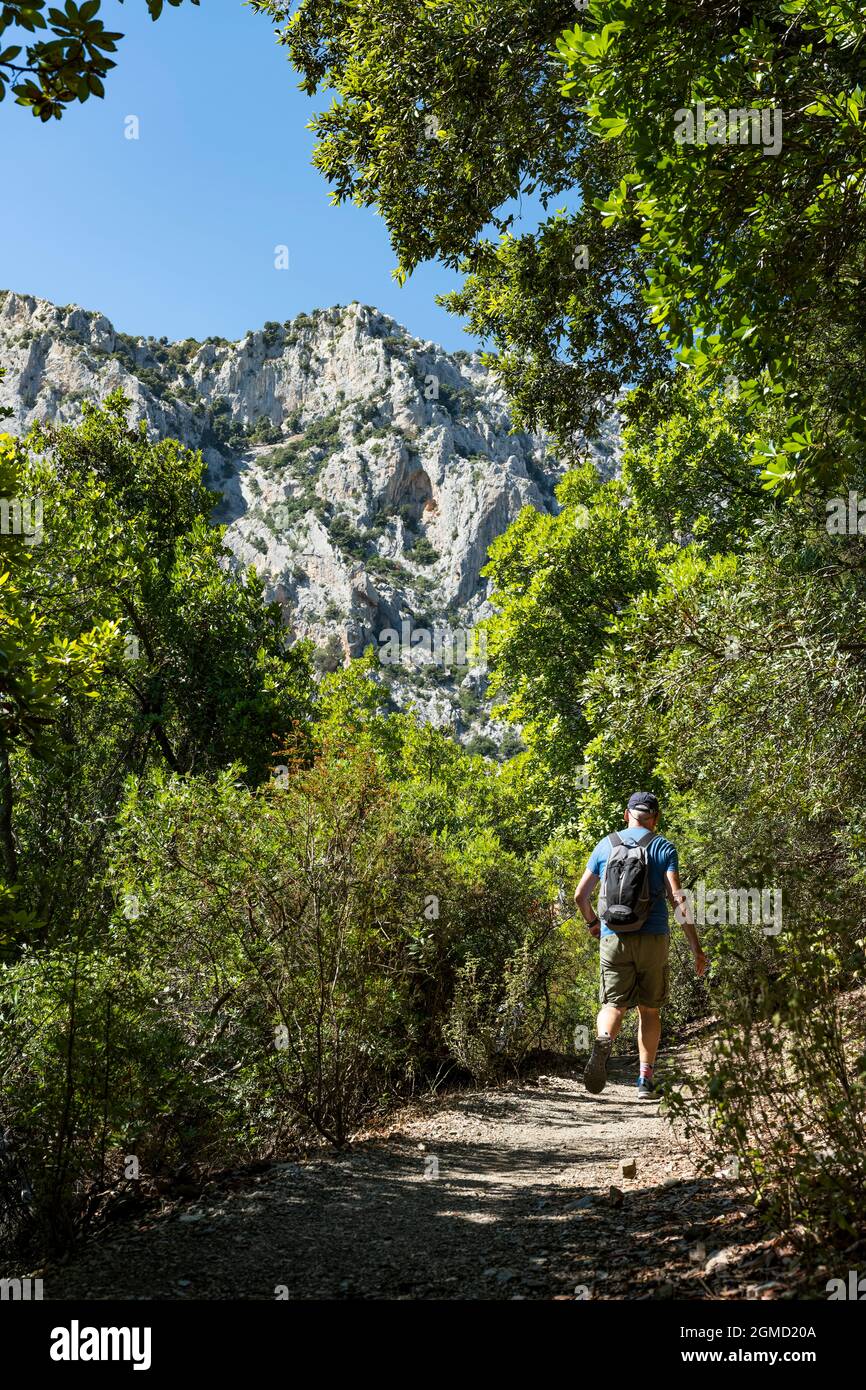 Stunning view of a tourist walking on a trail leading to Gorropu gorge ...