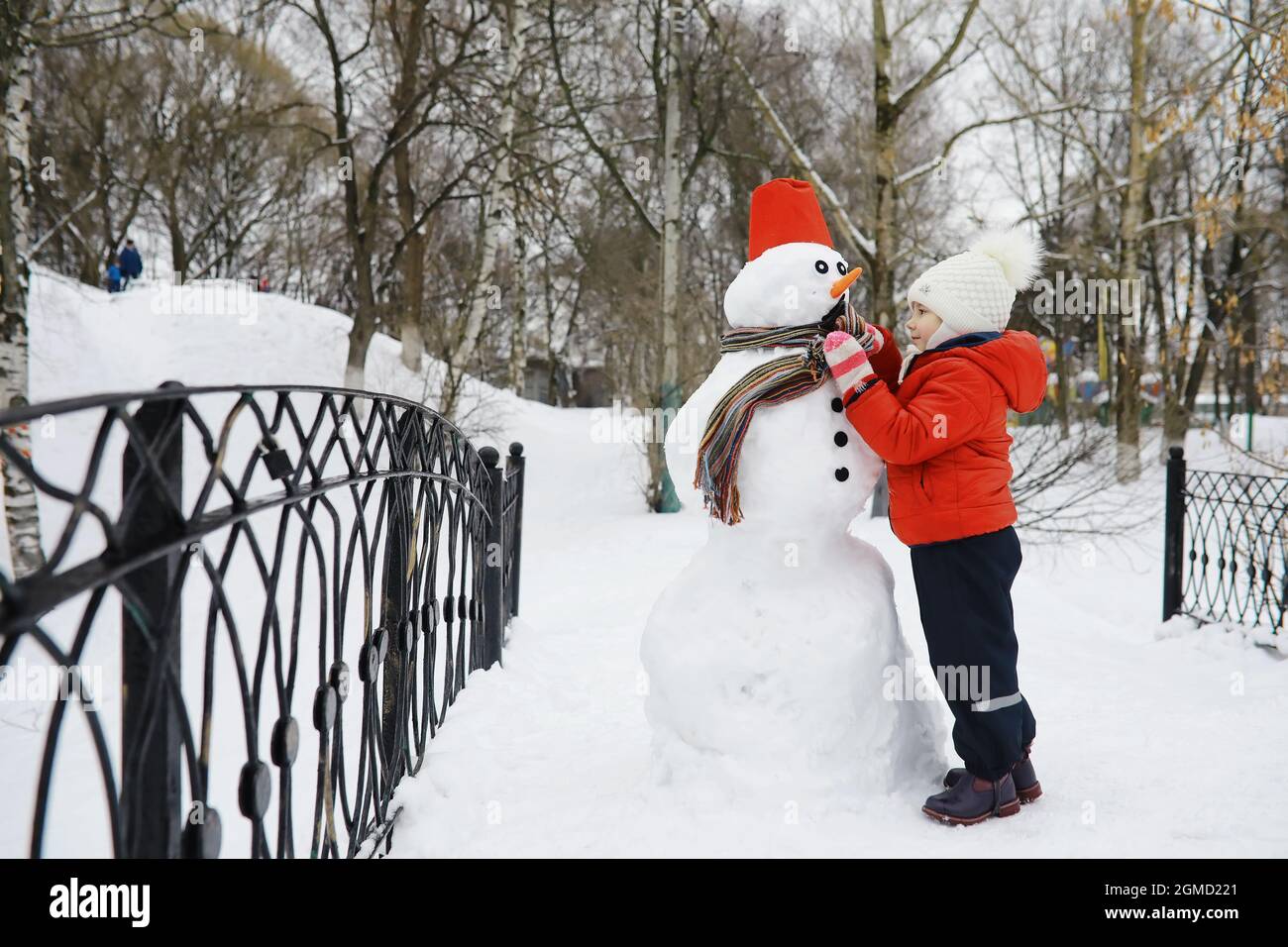 Children in the park in winter. Kids play with snow on the playground ...