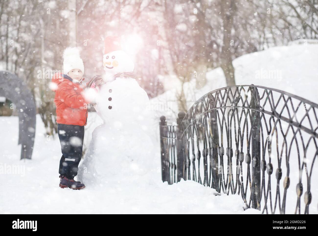 Children in the park in winter. Kids play with snow on the playground ...