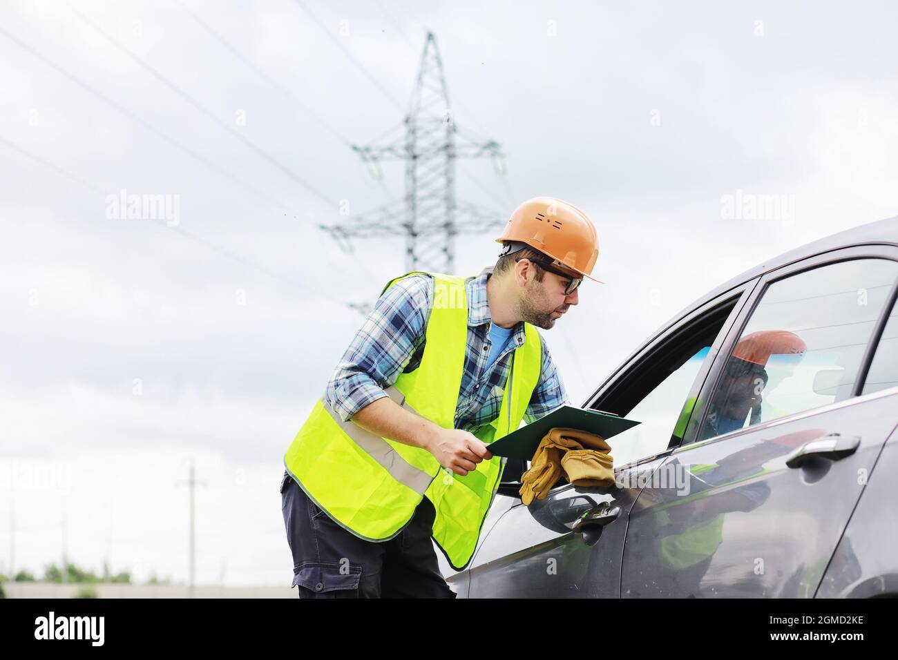 A man in a helmet and uniform, an electrician in the field ...
