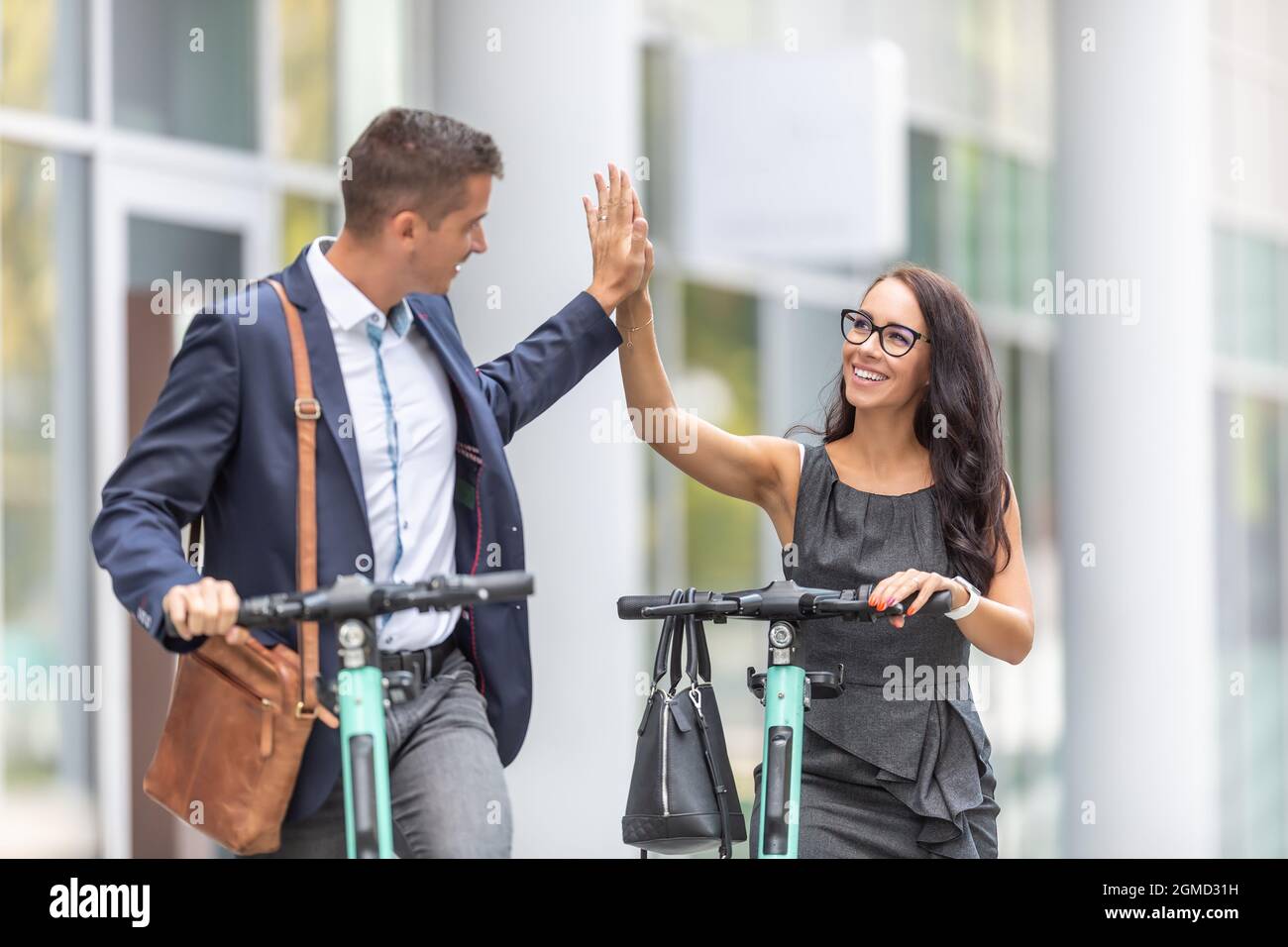Modern mobility and e-scooters using colleagues giving a high-five ...