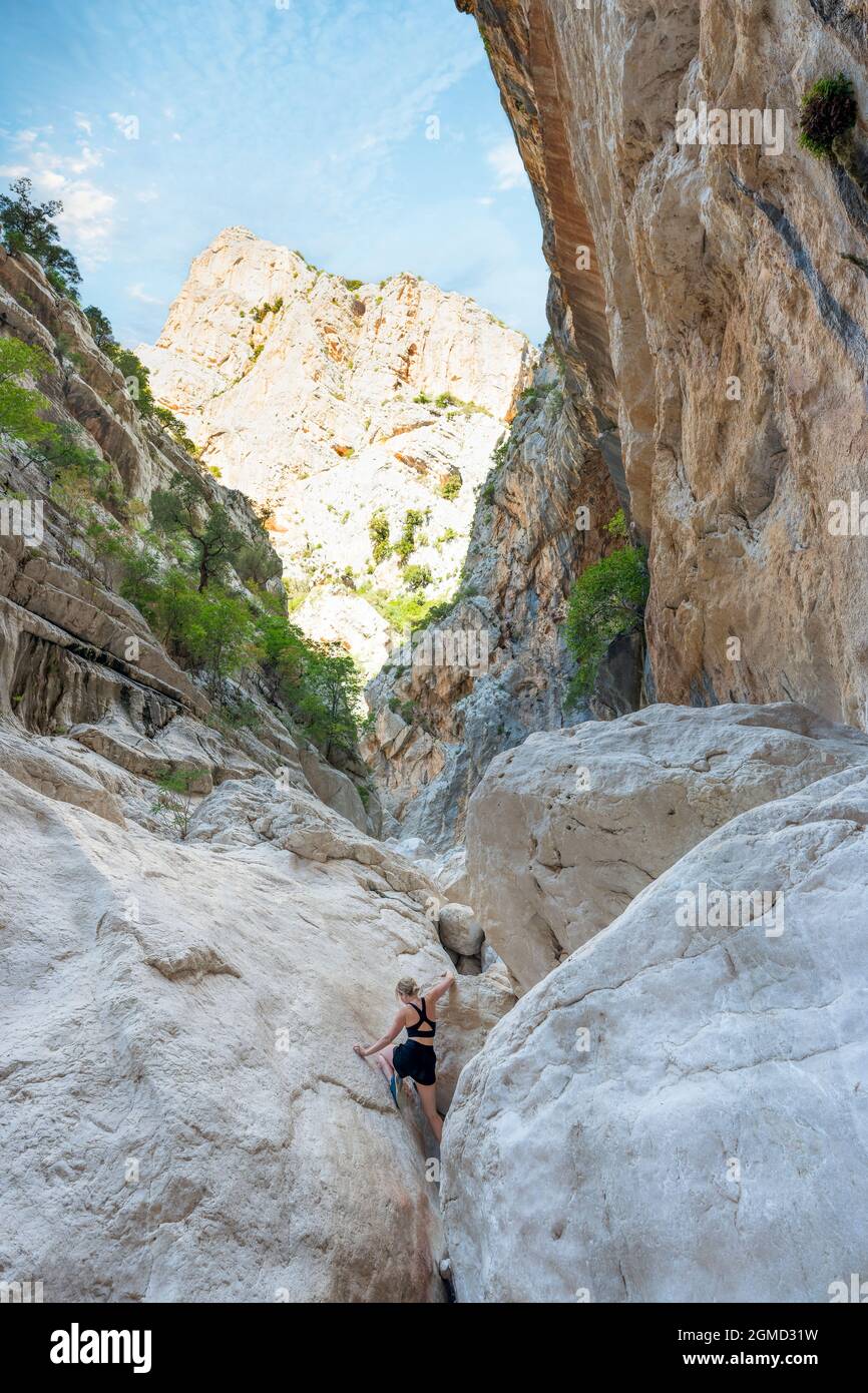 Stunning view of a person climbing a rock in the Gorropu gorge Stock ...