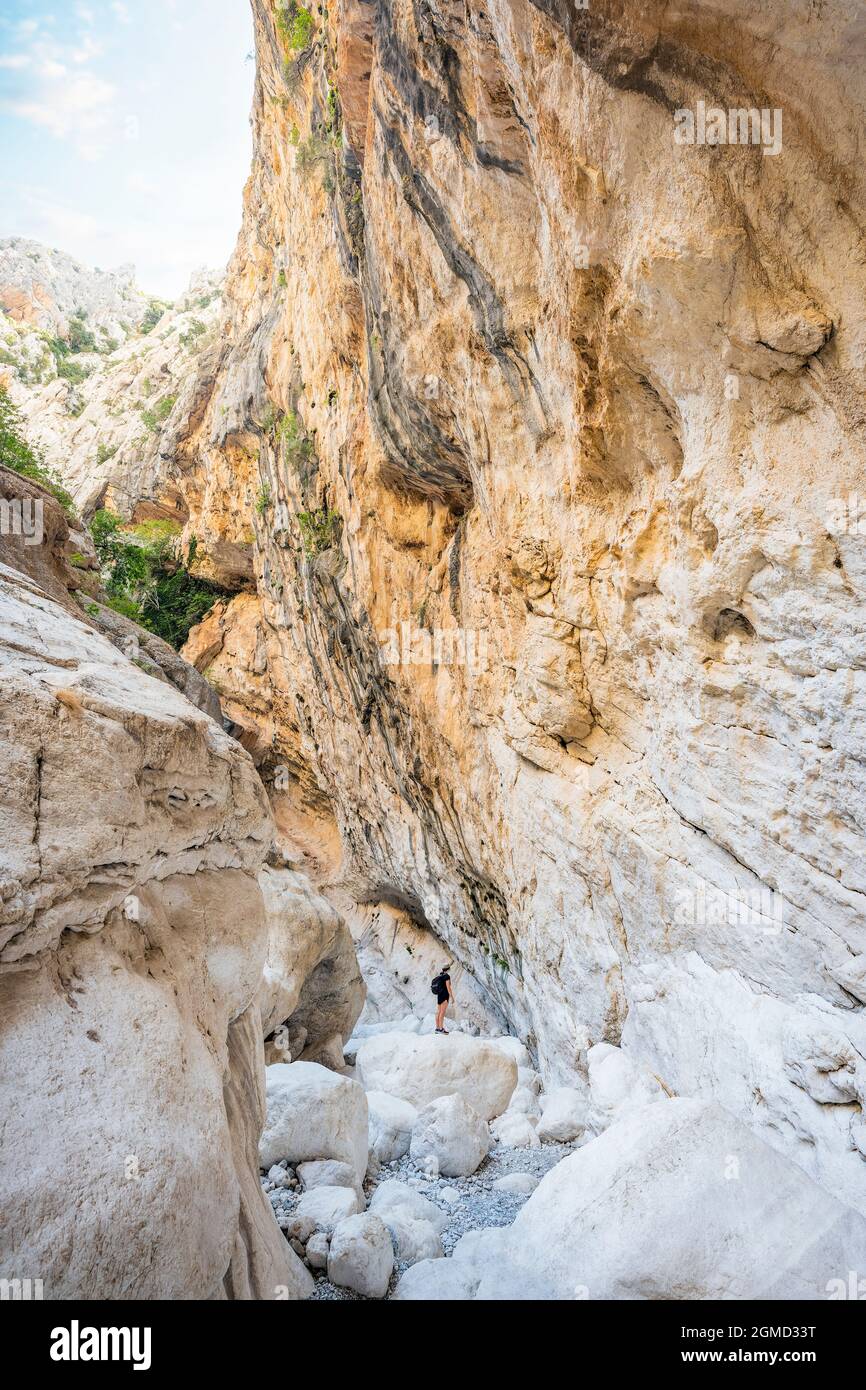 Stunning view of a person climbing a rock in the Gorropu gorge Stock ...