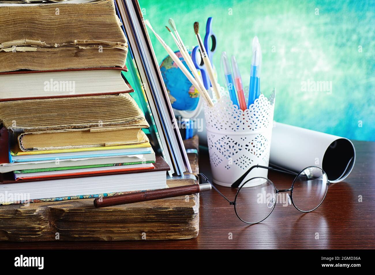 Education concept. A stack of textbooks and a book on the desk with ...