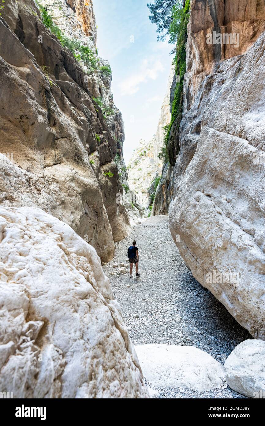 Stunning view of a person hiking in the Gorropu gorge during a sunny ...